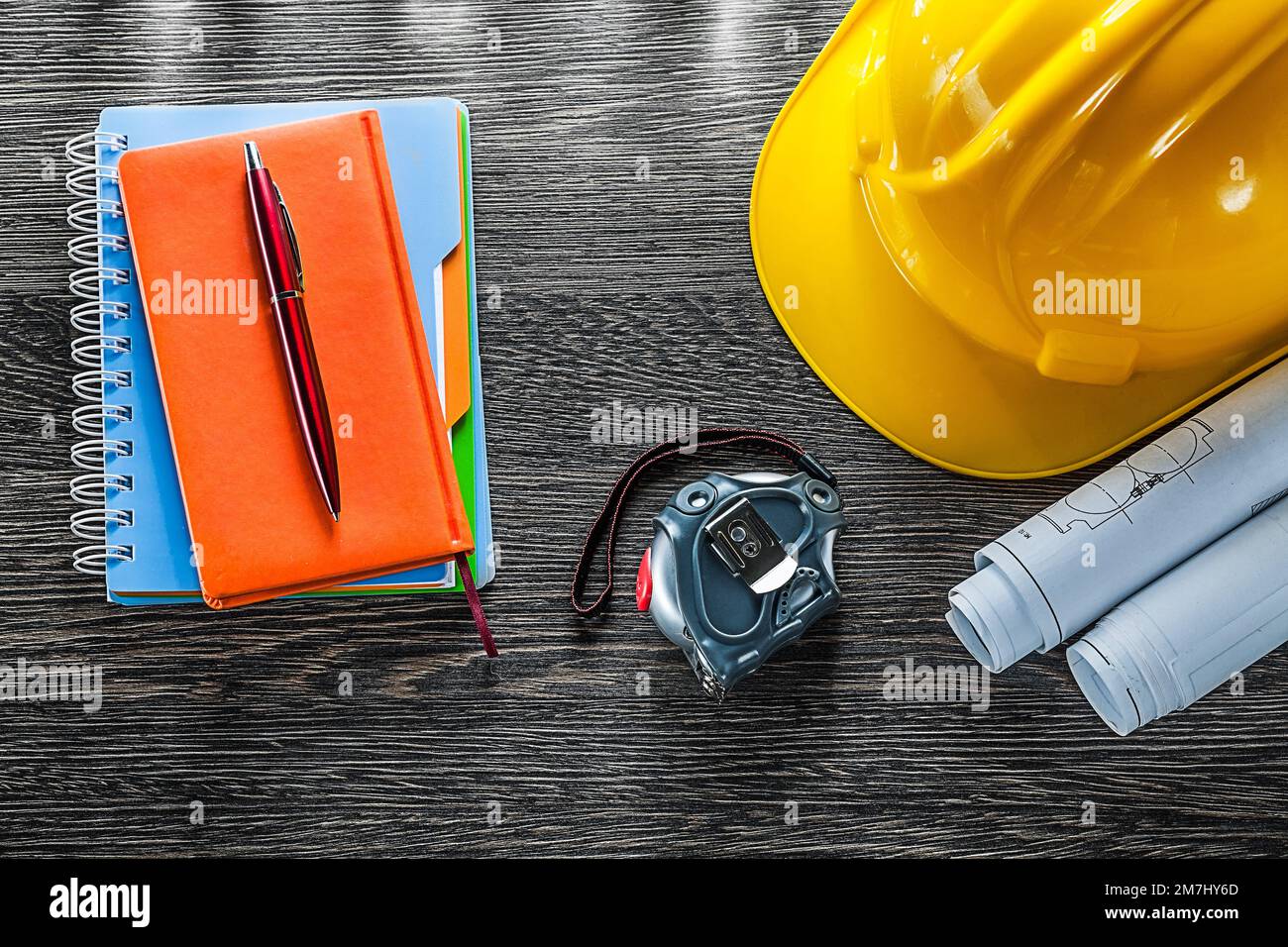 Construction plans tape measure building helmet notepads pen on wood ...