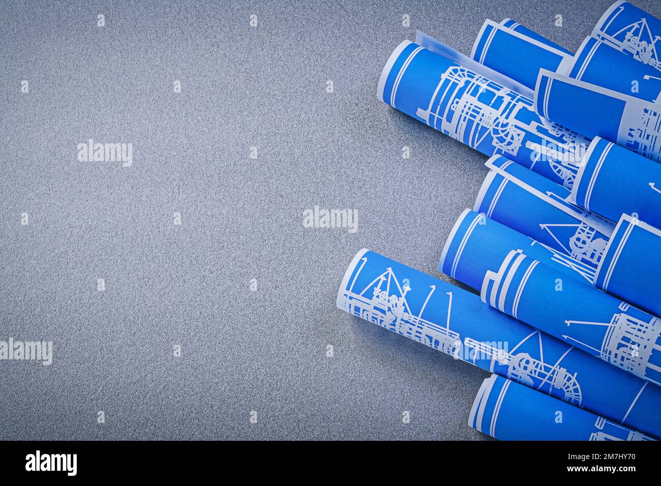 Copy space of blue rolled blueprints on grey background construction ...