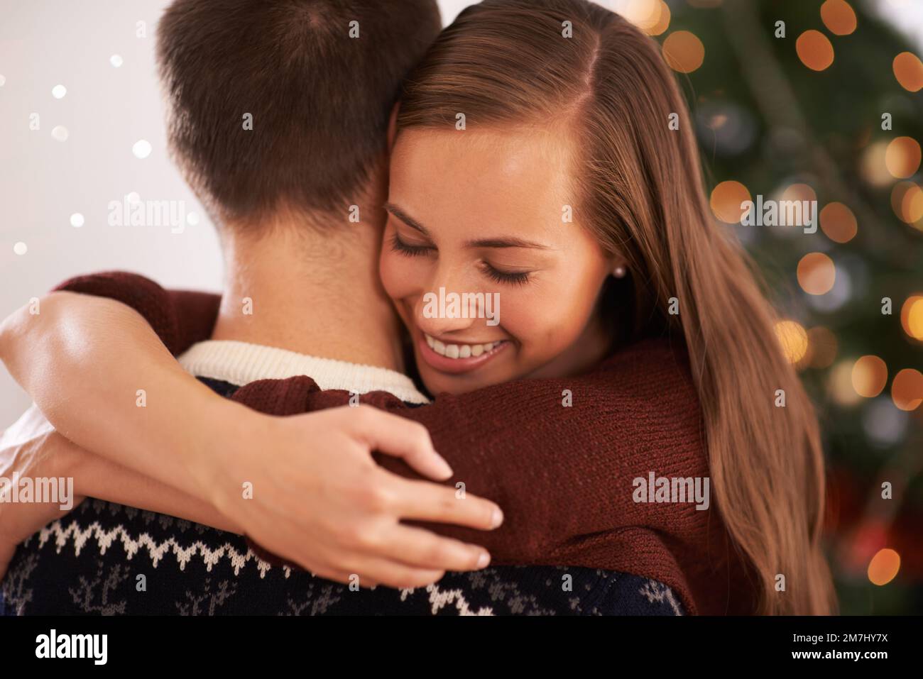 Embracing the joy of Christmas together. An attractive young woman ...