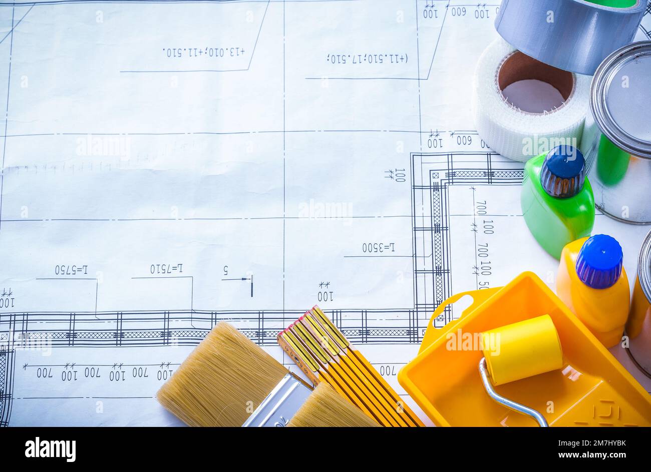 Duct tape wooden meter and paint tools on construction drawing vertical ...