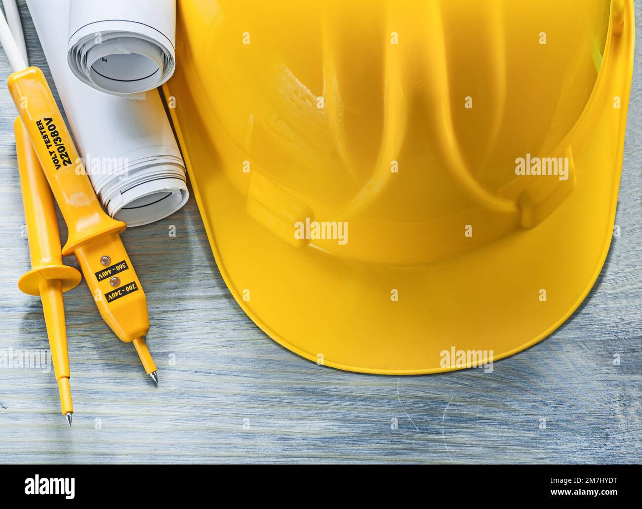 Electric tester protective hard hat engineering drawings on wood board ...