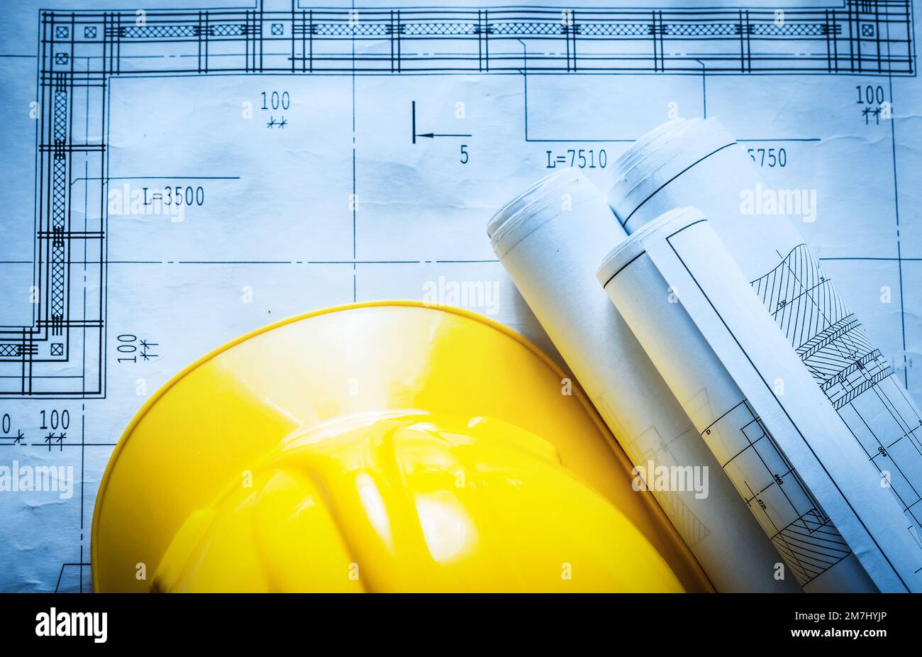 Hard hat construction drawings on blueprint Stock Photo - Alamy