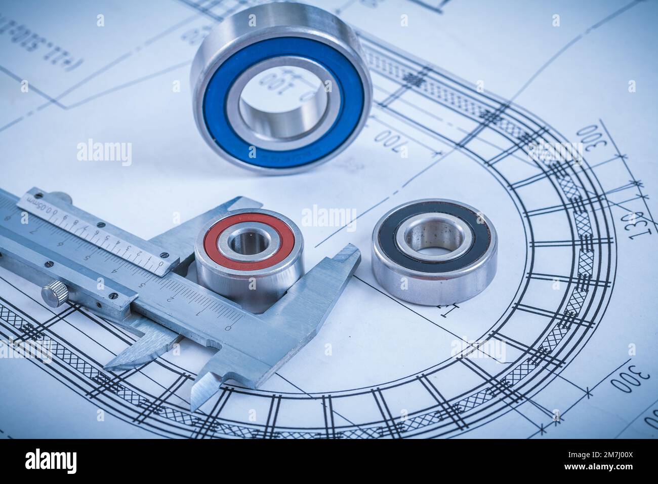 Metal roller bearings and trammel caliper on blueprint construction ...
