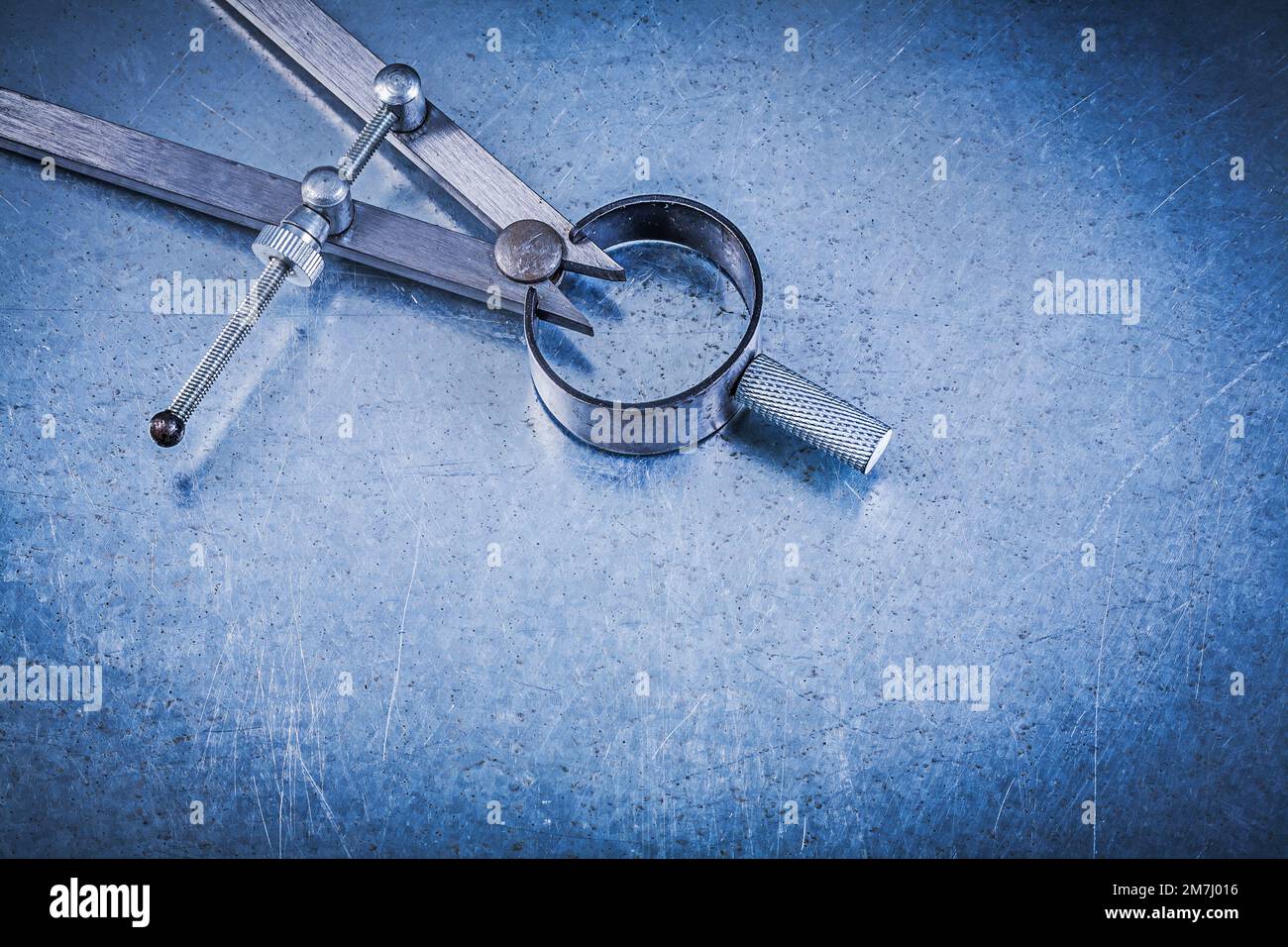Metal construction drawing compass on metallic background directly ...