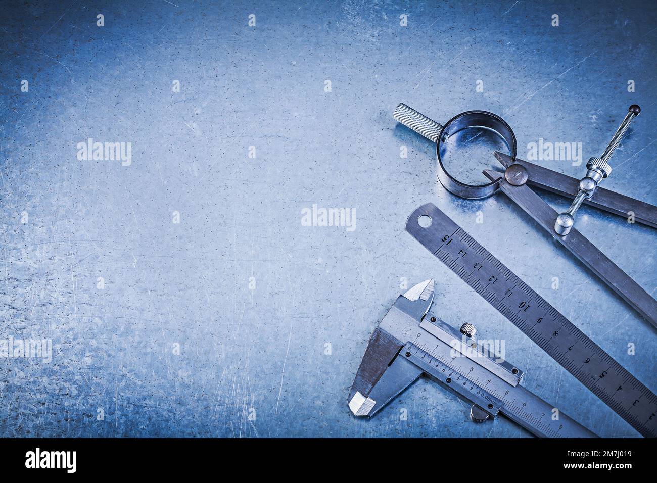 Metal construction drawing compass ruler caliper on metallic background ...