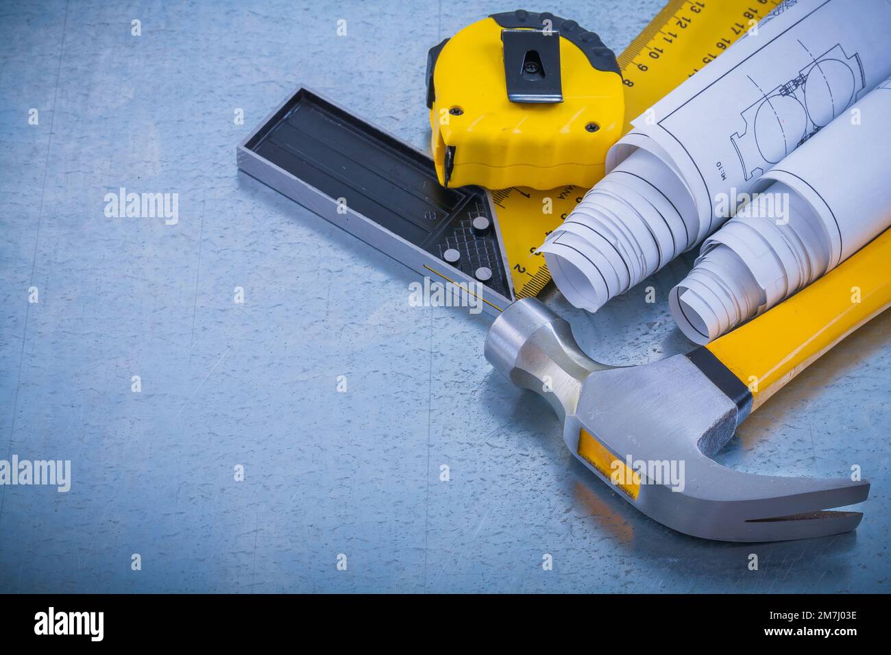 Metallic background with blueprints claw hammer square ruler and ...