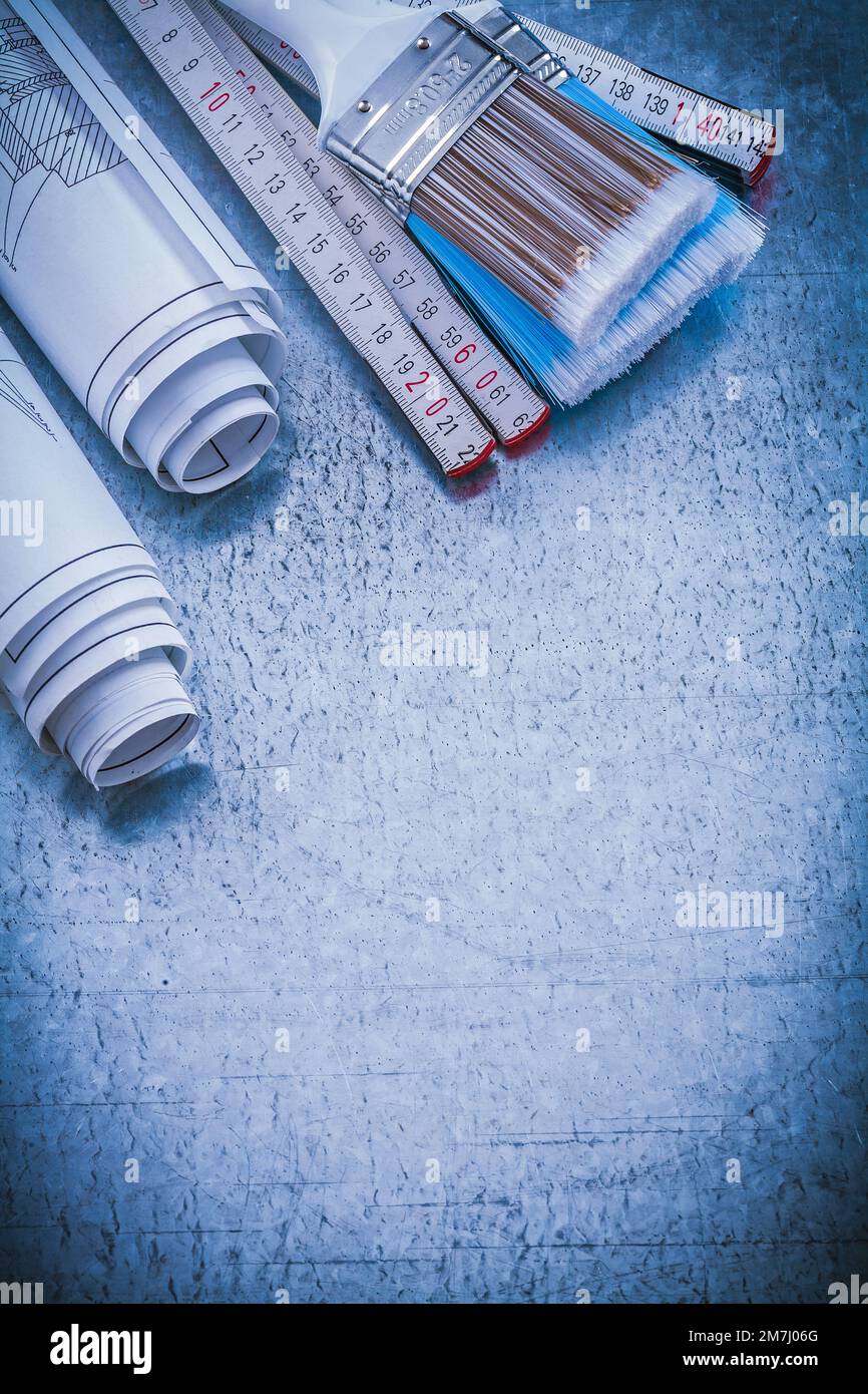 Paintbrushes wooden meter construction drawings on metallic background ...