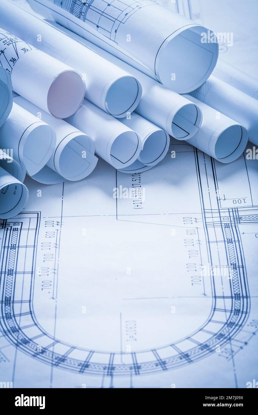 Pile of rolled up construction plans building and architecture concept ...