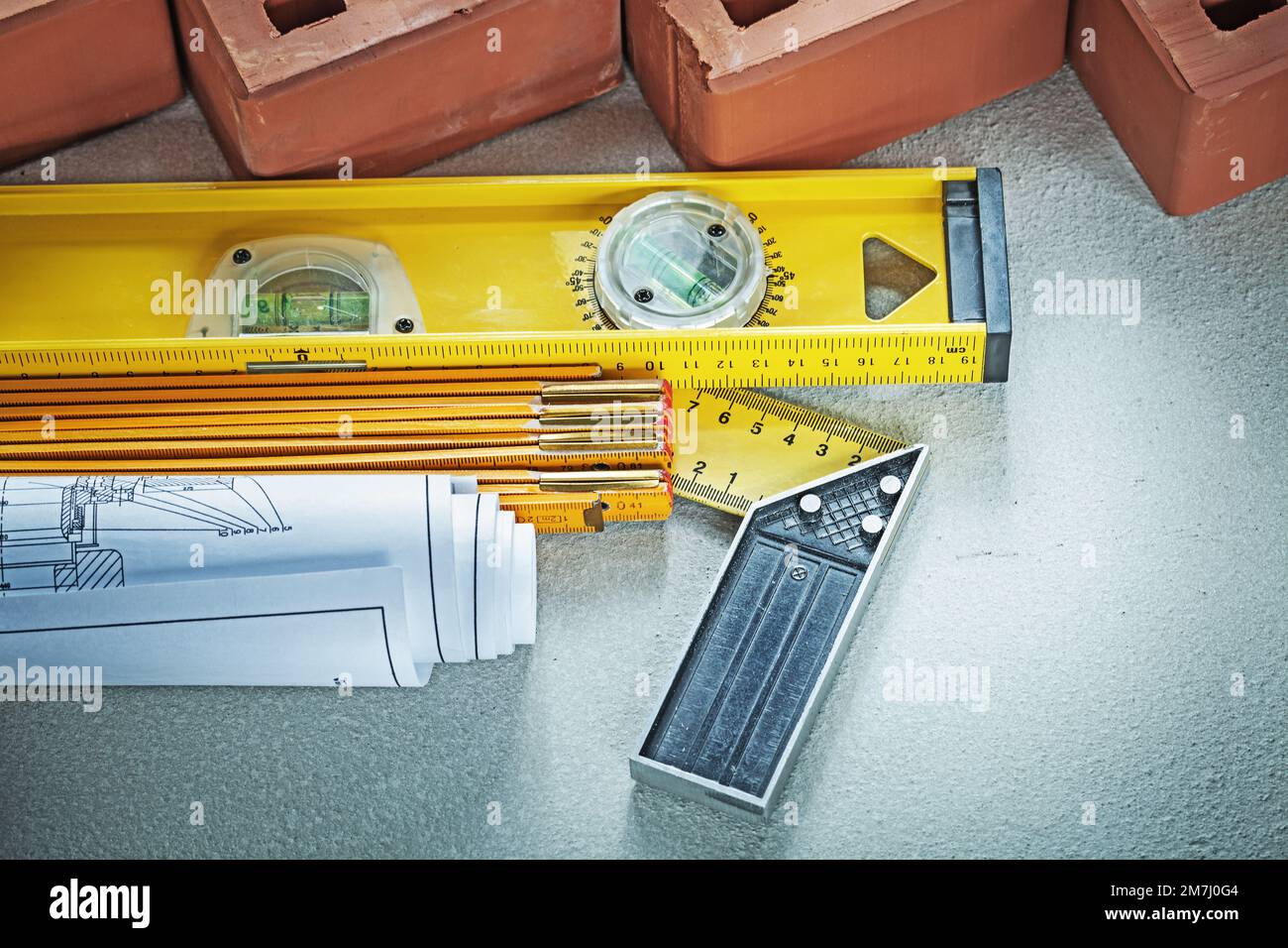 Red bricks construction level wooden meter blueprints square ruler on ...