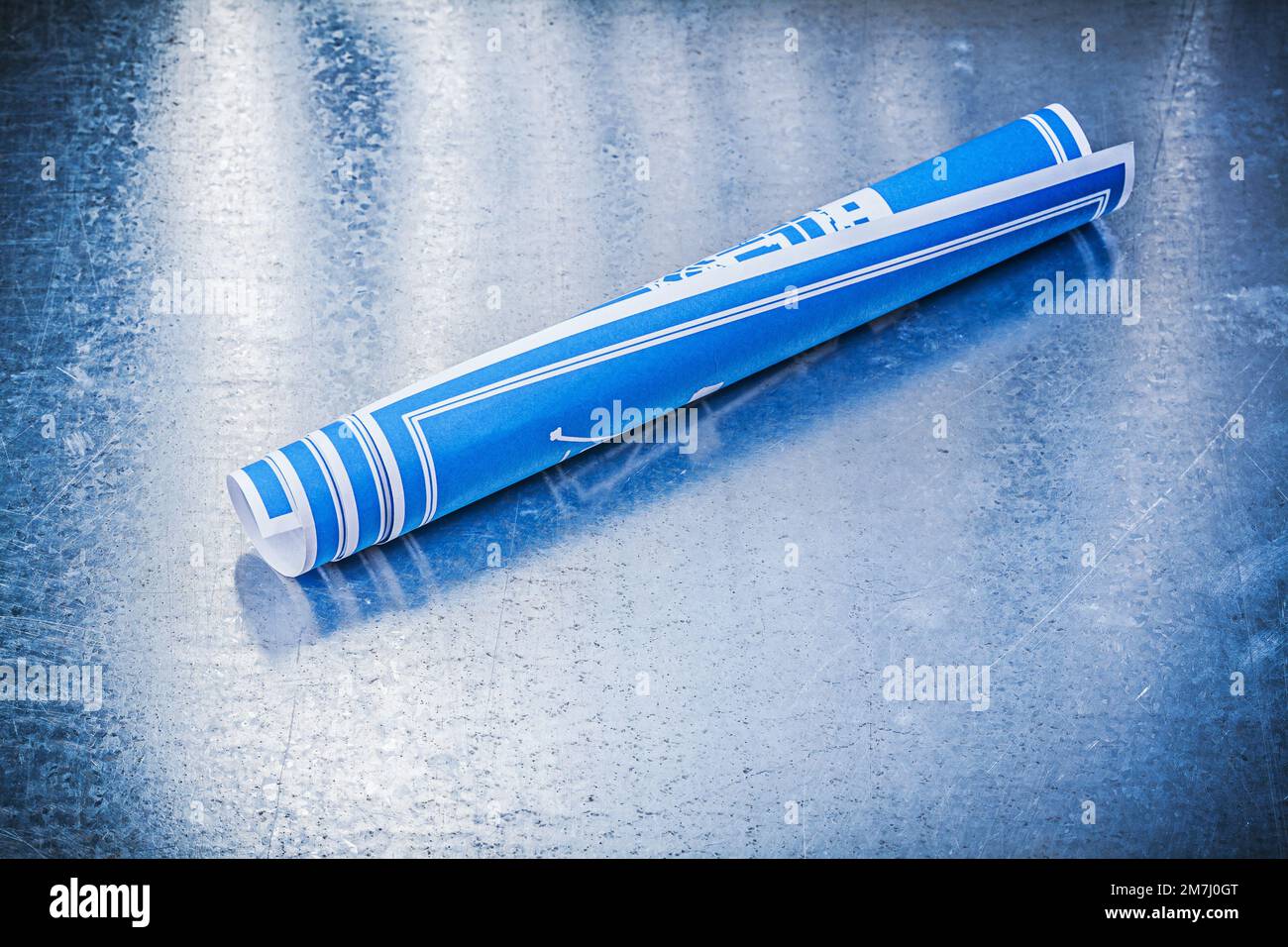 Roll of blue engineering drawings on metallic background construction ...