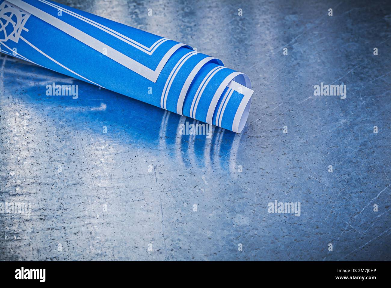 Roll of blue construction plans on metallic background building concept ...