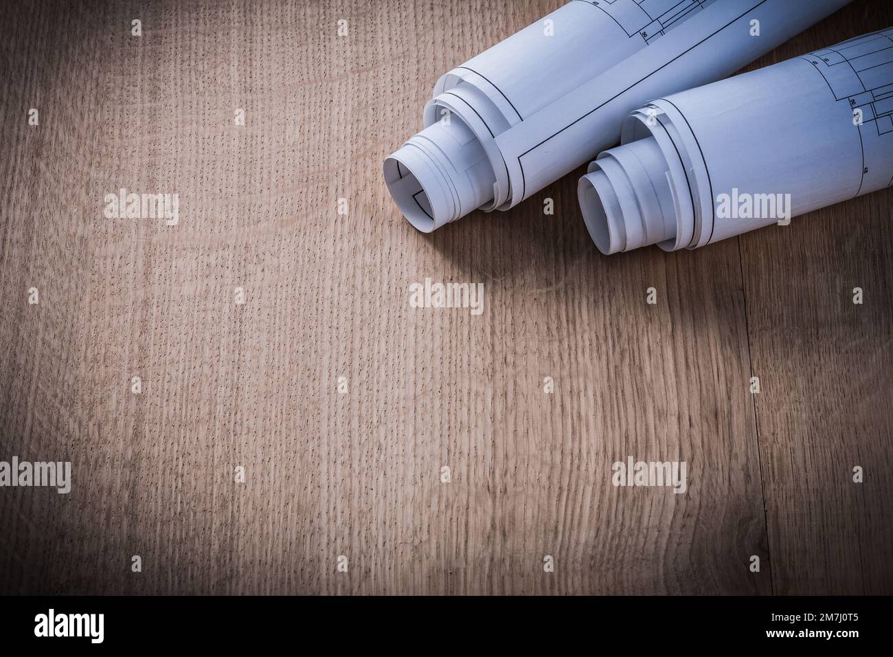 Rolled construction drawings on wood board architecture and building ...