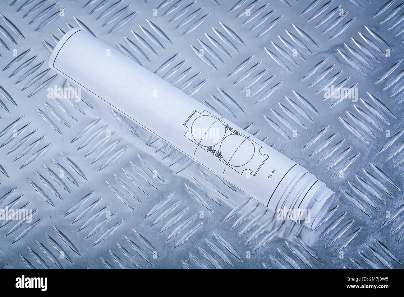 Rolled engineering drawings on grooved metal sheet top view ...