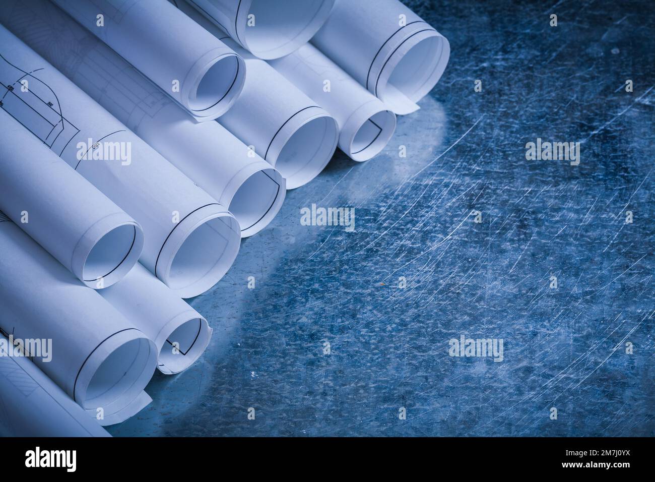 Rolled up blueprints on scratched vintage metallic background ...