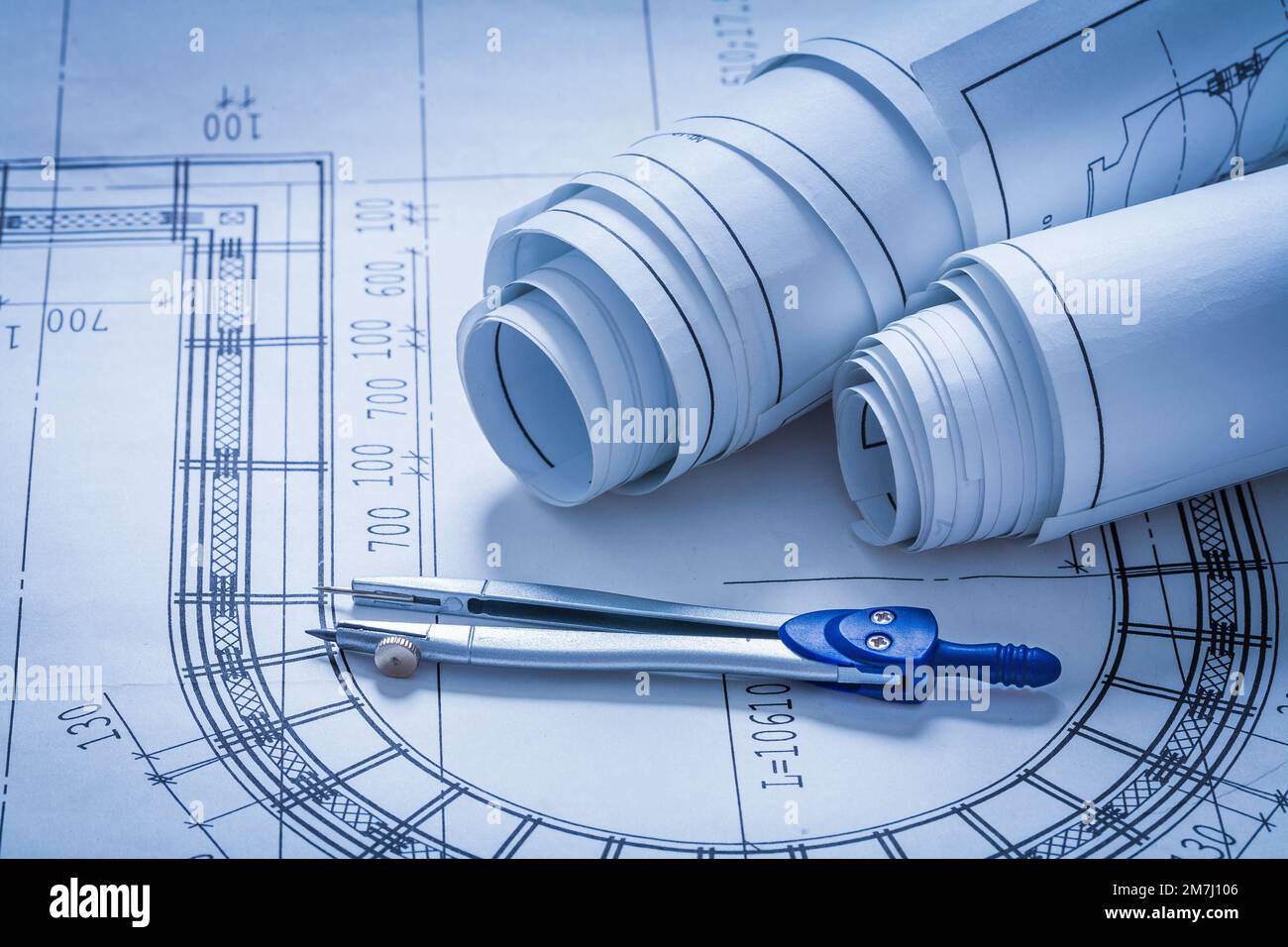 Rolled up construction sketches and drawing compass building concept ...