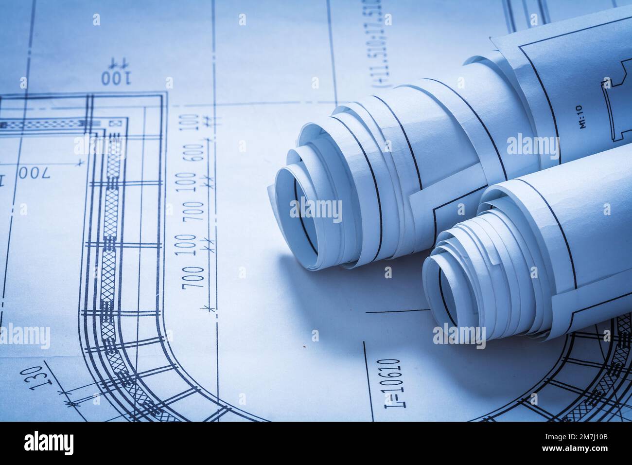 Rolled up construction sketches building concept Stock Photo - Alamy