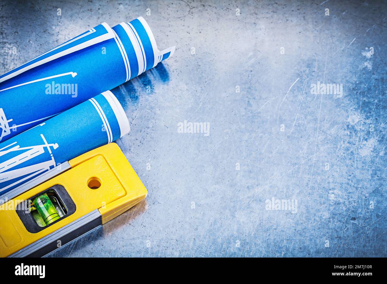 Rolled up engineering drawings construction level on metallic ...