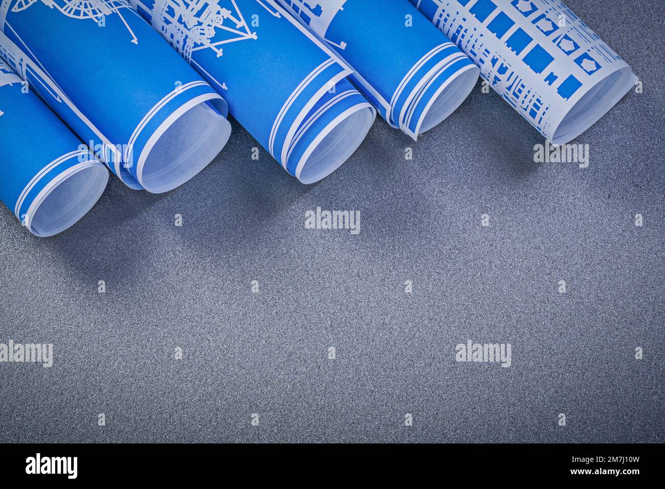 Rolls of blue engineering drawings on grey background construction ...