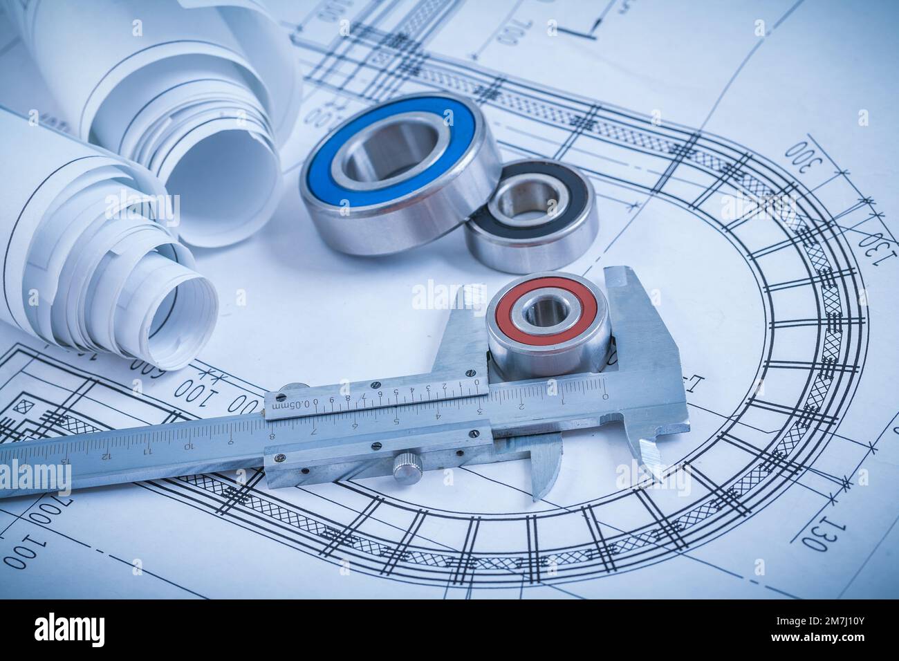 Rolled up construction plans roller bearings and slide caliper on ...