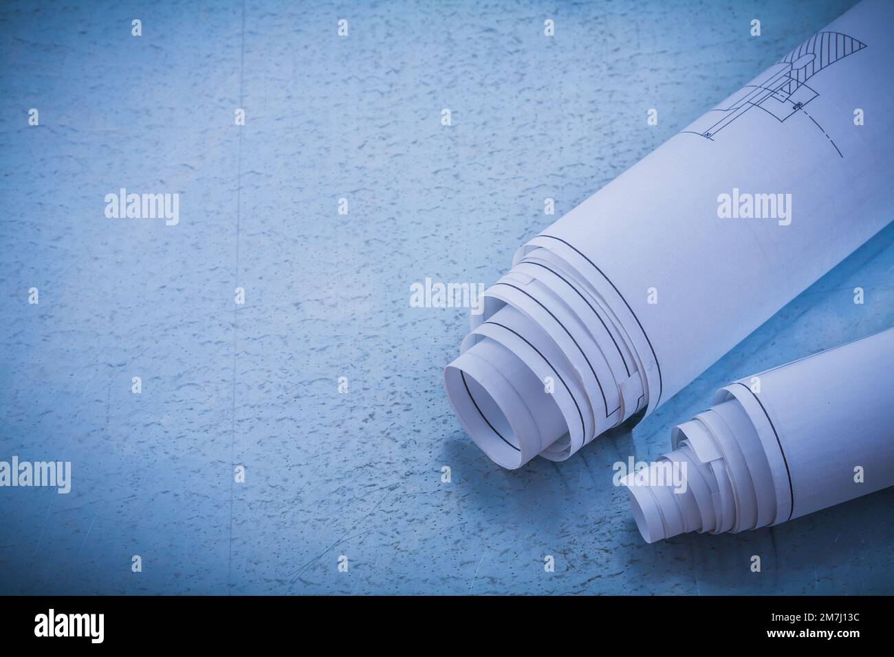Rolls of construction plans on metallic background building and ...
