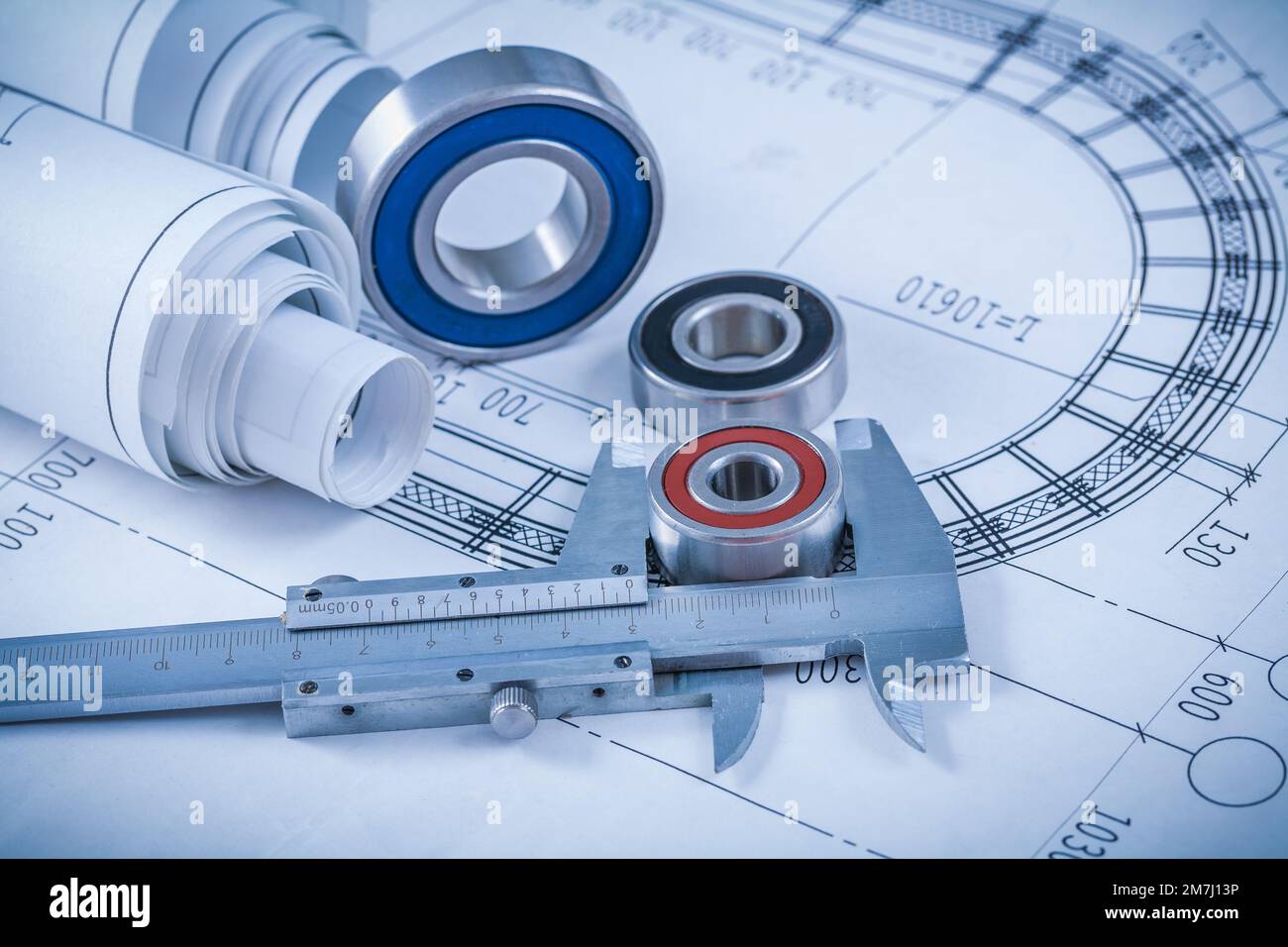 Rolls of construction plans rolling bearings and slide caliper on ...