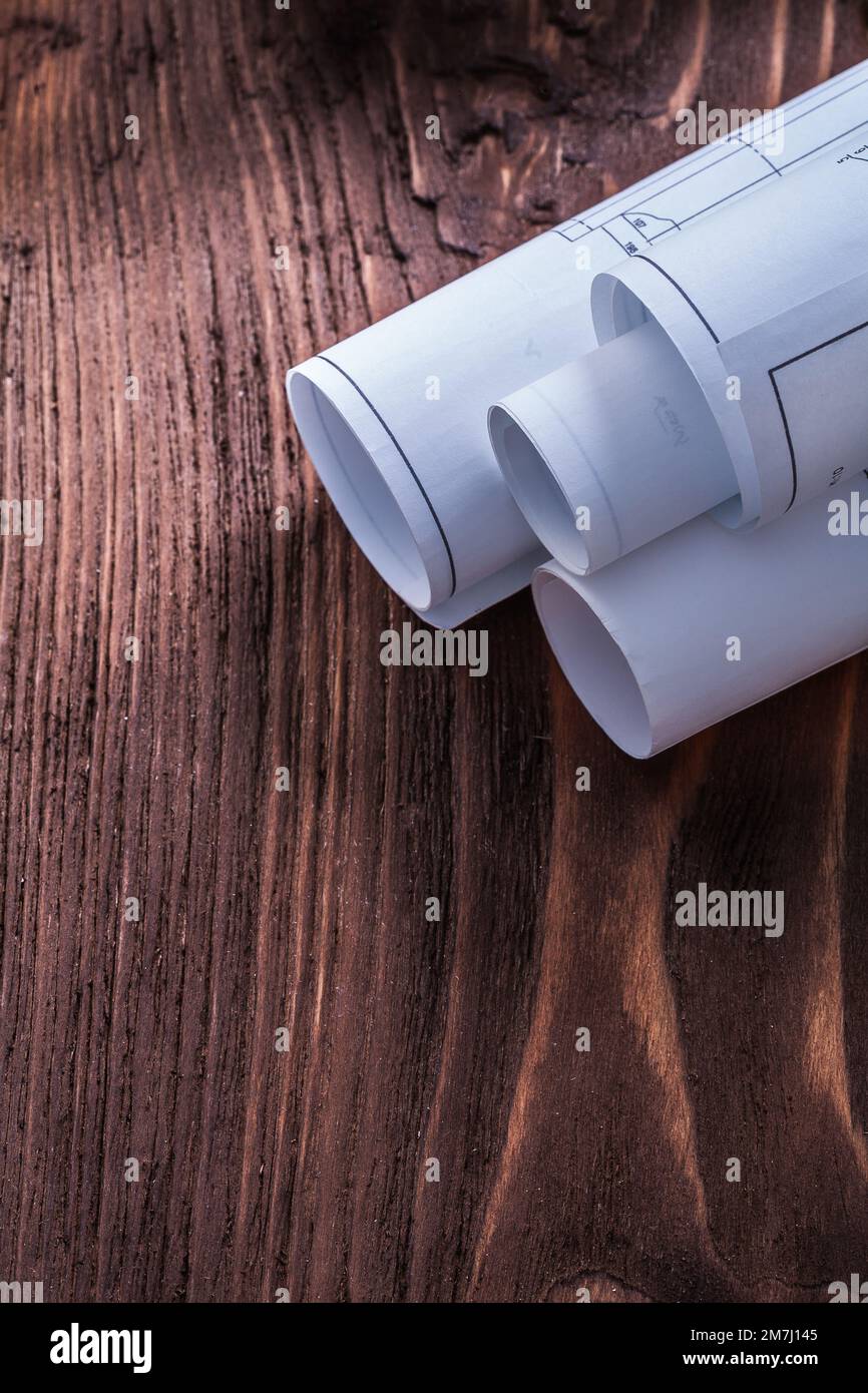 Rolls of construction plans on vintage brown wooden board maintenance ...
