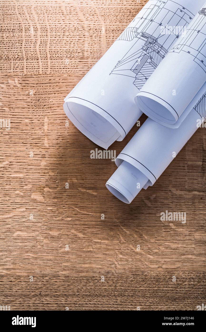 Rolls of construction plans on wooden oaken board maintenance concept ...