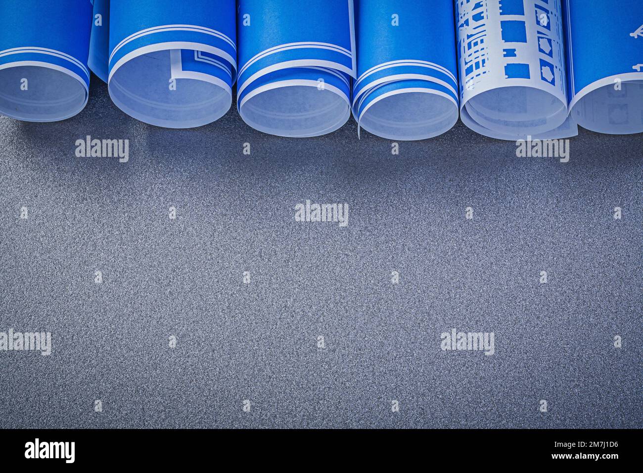 Stack of blue engineering drawings on grey background copy space ...