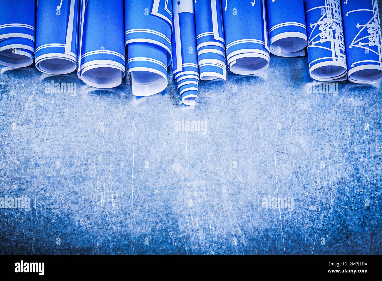 Stack of blue blueprints on metallic background construction concept ...