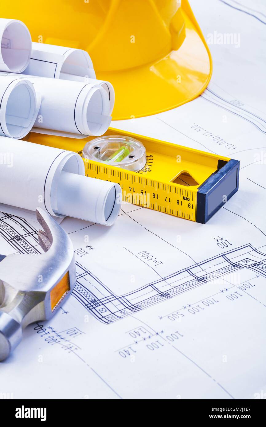 stack of rolls blueprints level hammer helmet Stock Photo - Alamy