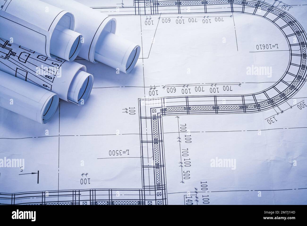 stack of white rolled blueprints with copyspace Stock Photo - Alamy