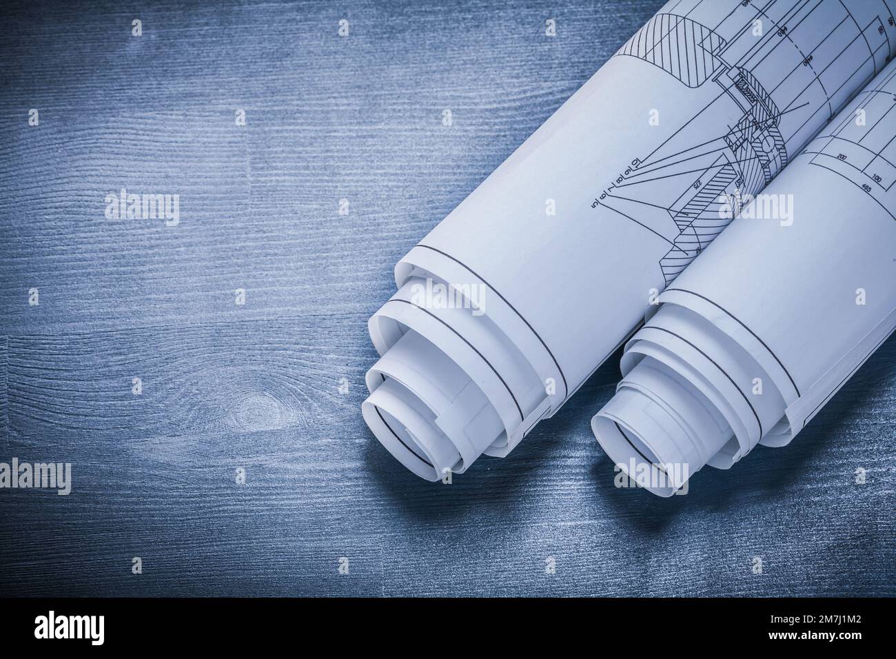 two rolls of blueprints on wood board Stock Photo - Alamy