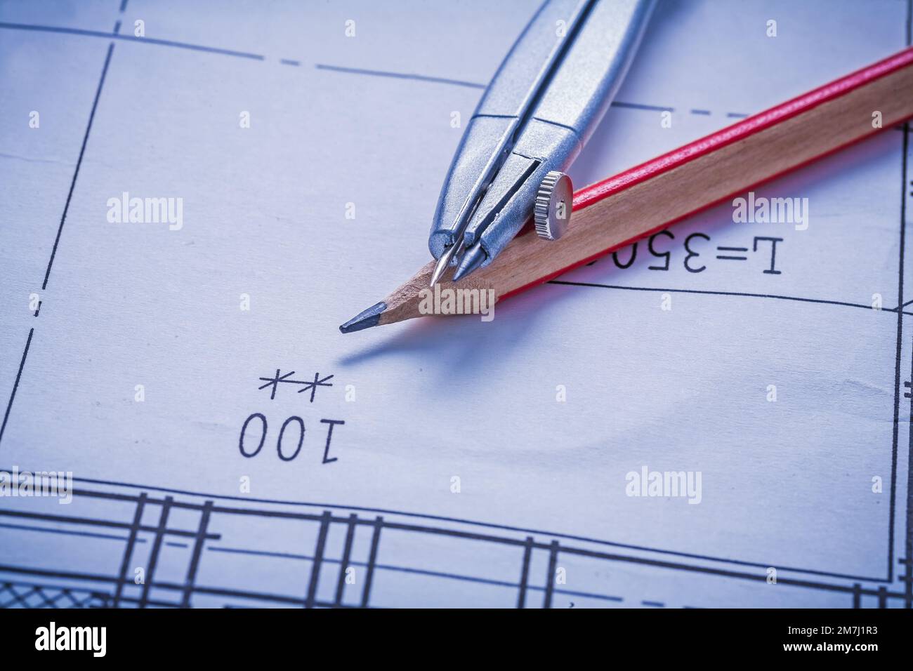 very close up view on classical compass and pencil on white blueprint ...