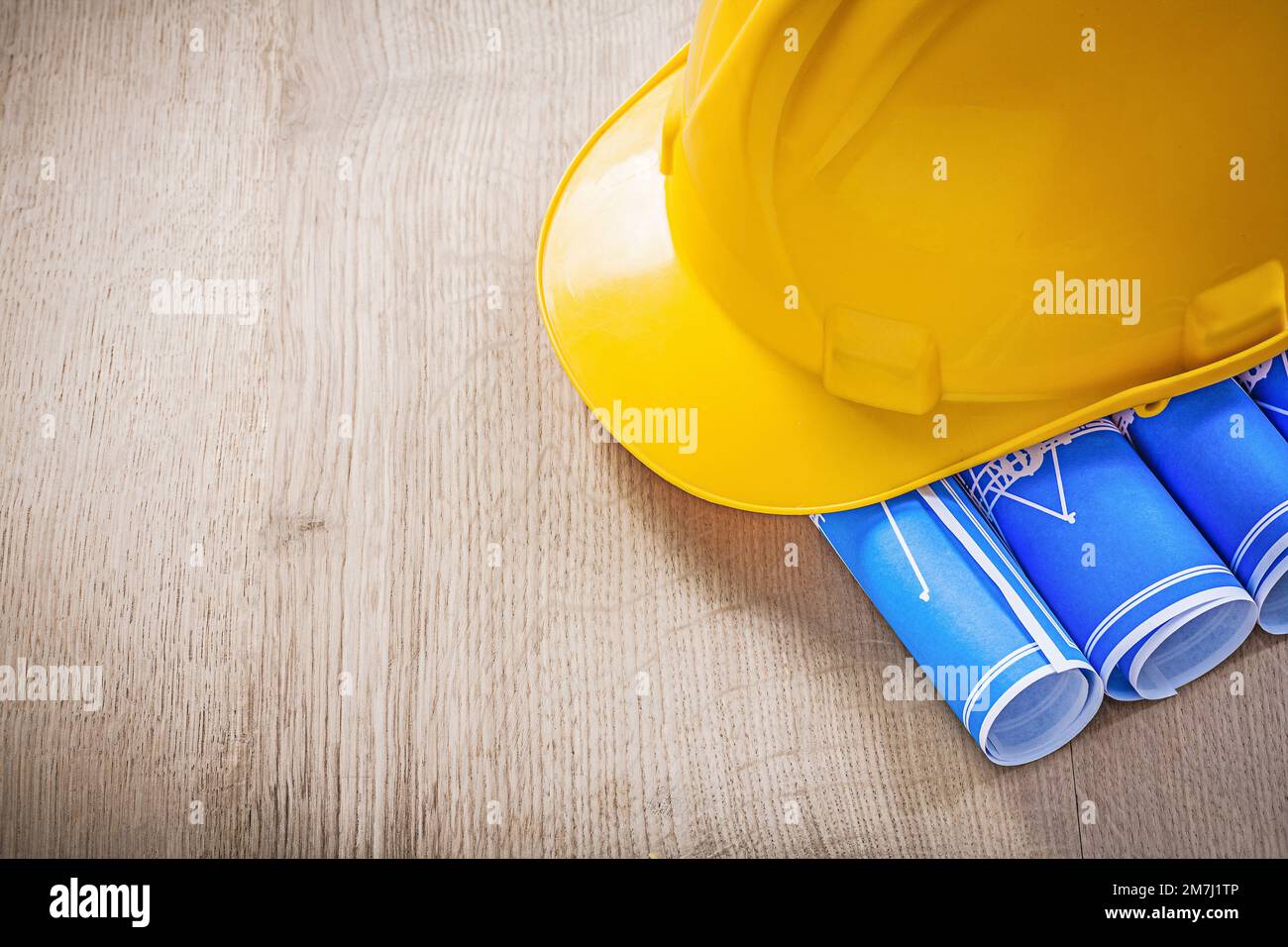 Wooden board with blue engineering drawings hard hat construction ...