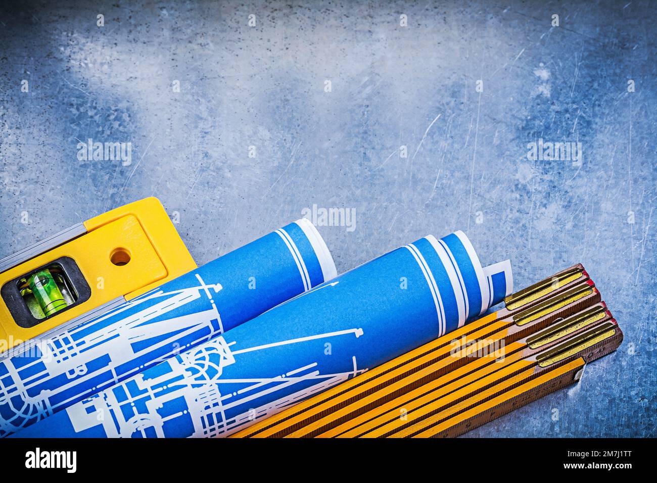 Wooden meter blue rolled construction plans level on metallic ...