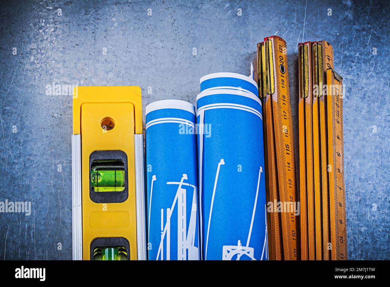 Wooden meter blue construction drawings level on metallic background ...