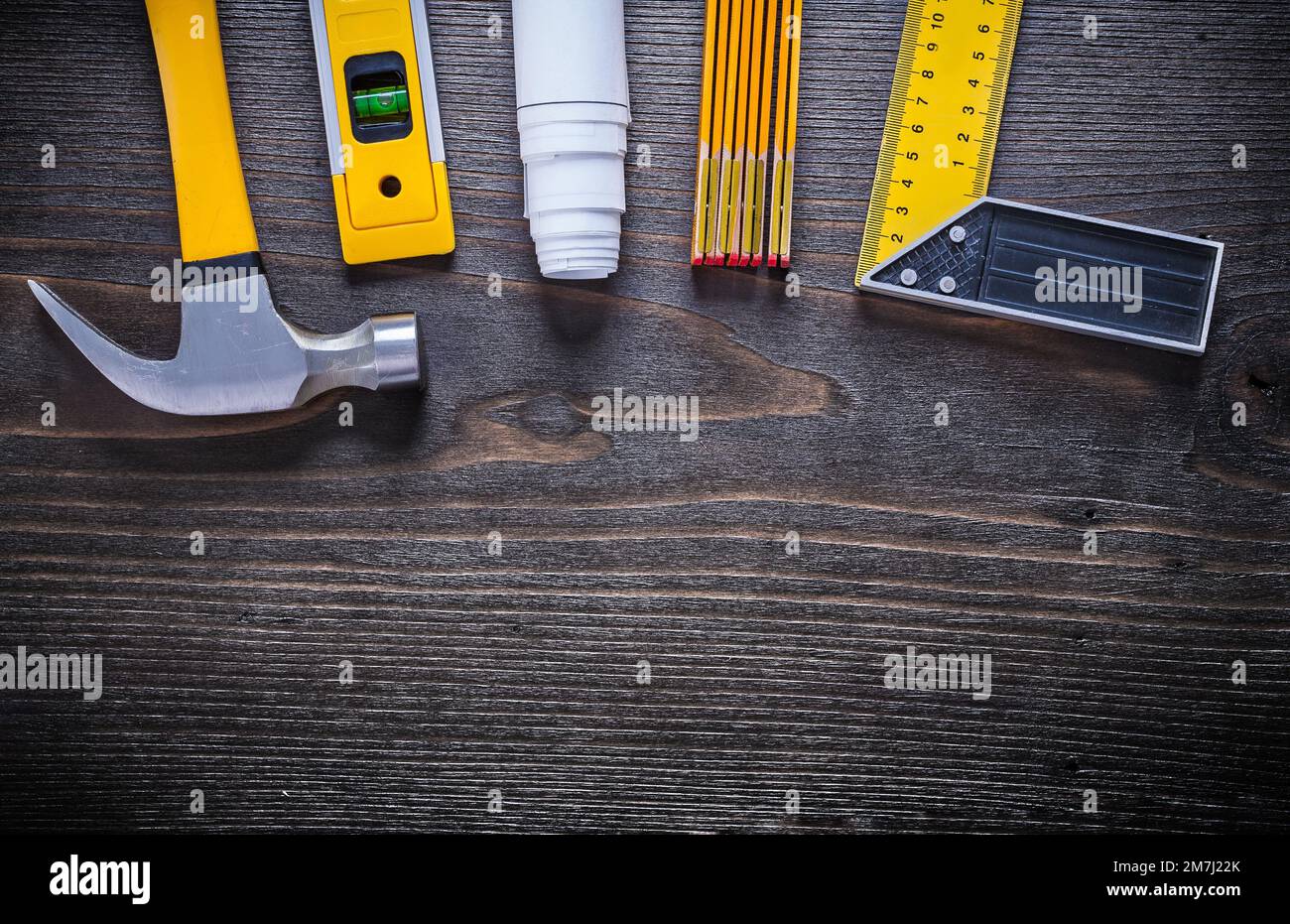Yellow construction level square ruler rolled up blueprint wooden meter ...