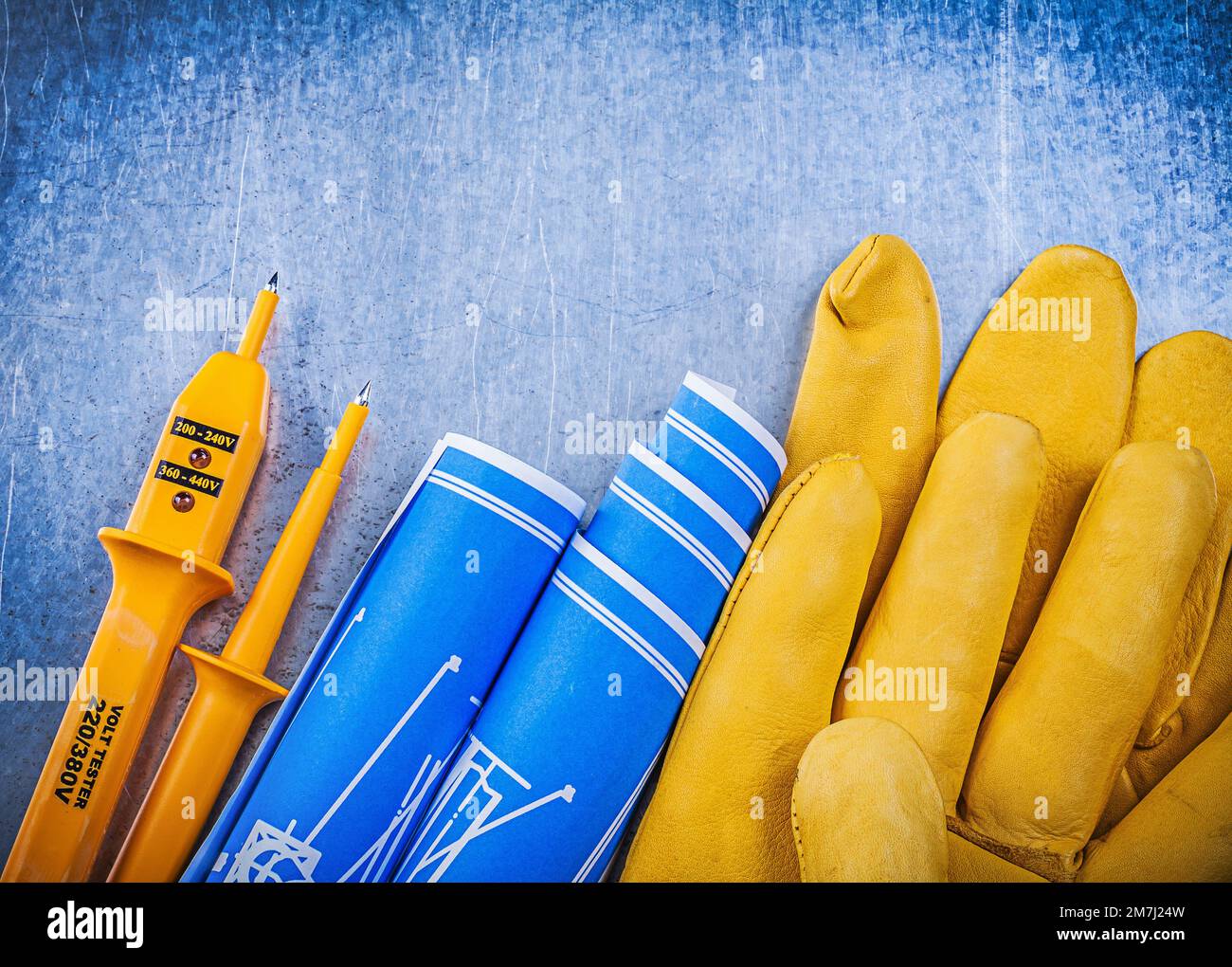 Yellow electrical tester safety gloves blue engineering drawings on ...