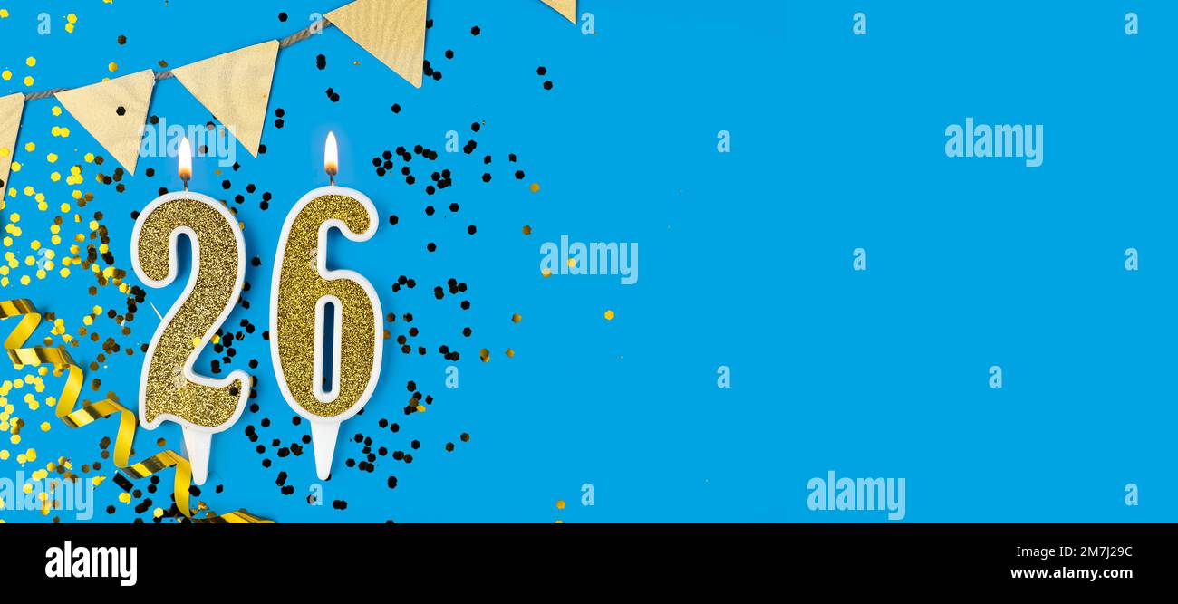 Number 26 gold celebration candle on star and glitter blue background ...