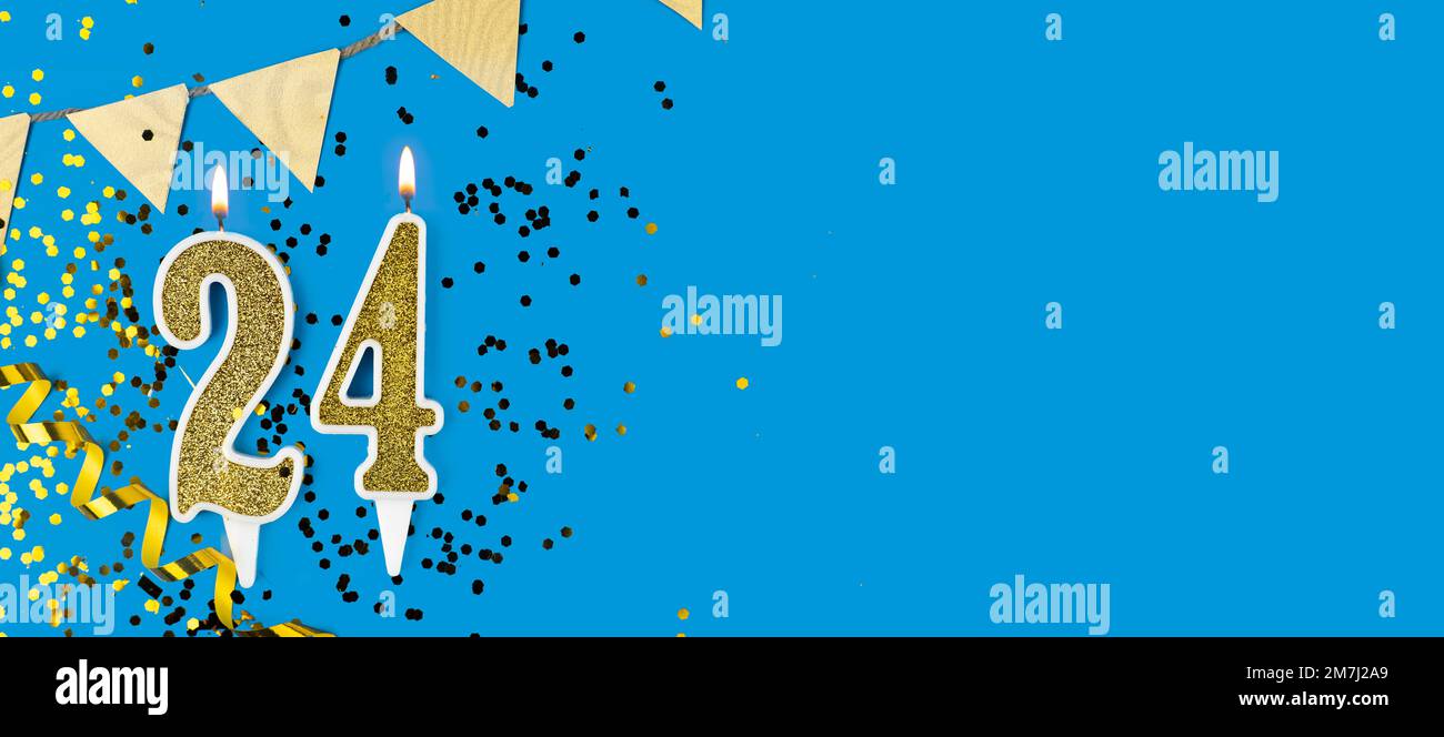 Number 24 gold celebration candle on star and glitter blue background ...