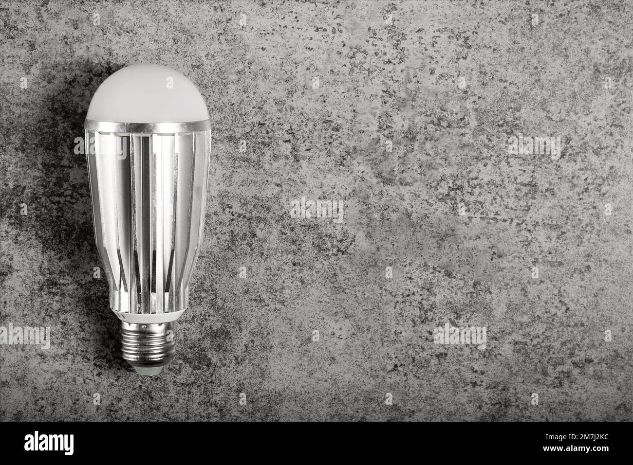 LED energy-saving lamp with big radiator and E27 screw cap base on gray ...