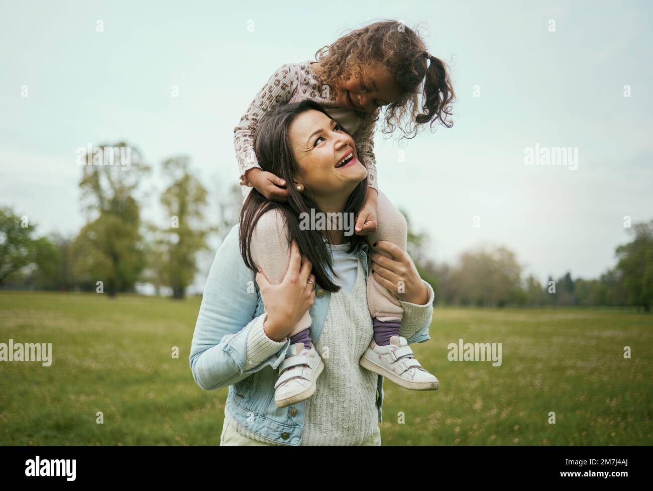 Park, mother and girl sitting shoulders for happiness, bonding or care ...