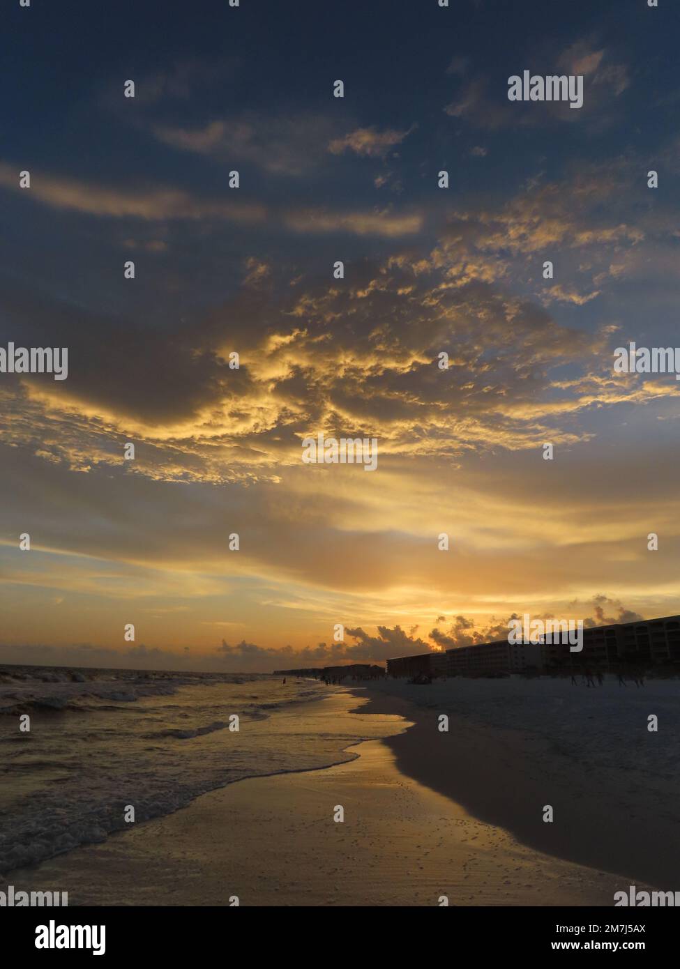 A breathtaking view of colorful sunset clouds over the foamy sea and ...