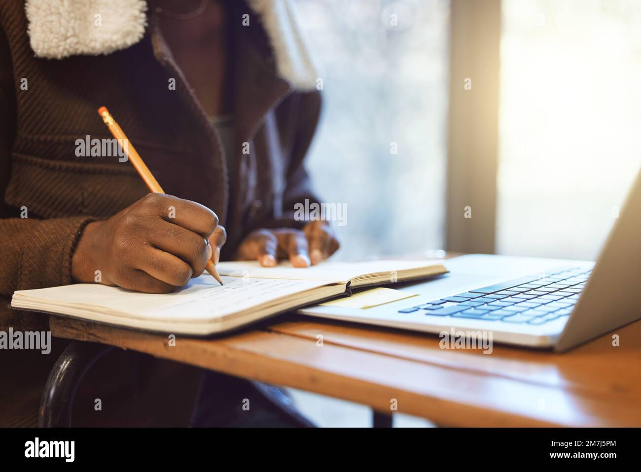 Student, hands and writing in notebook, studying and learning for exams ...