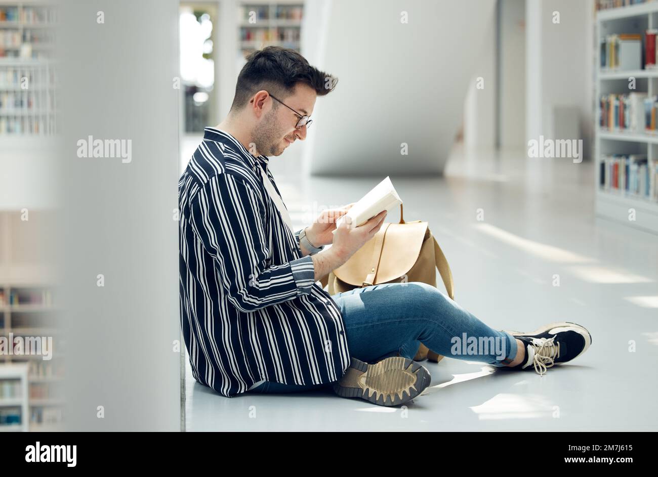 Man, student and reading in library with book for knowledge, education ...
