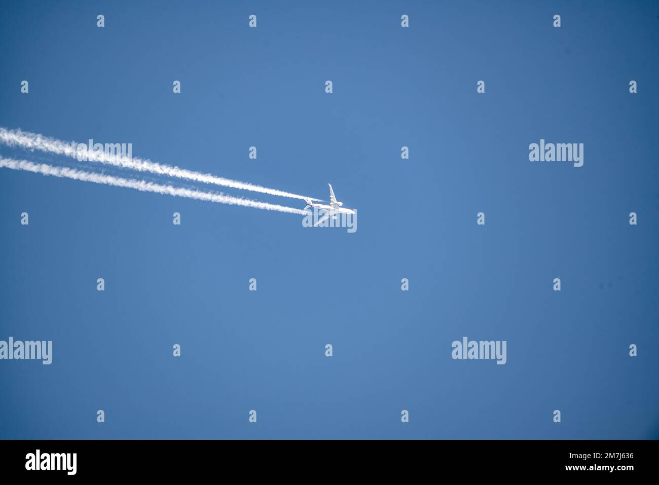 A jet plane flying overhead diagonally with condensation trail Stock ...