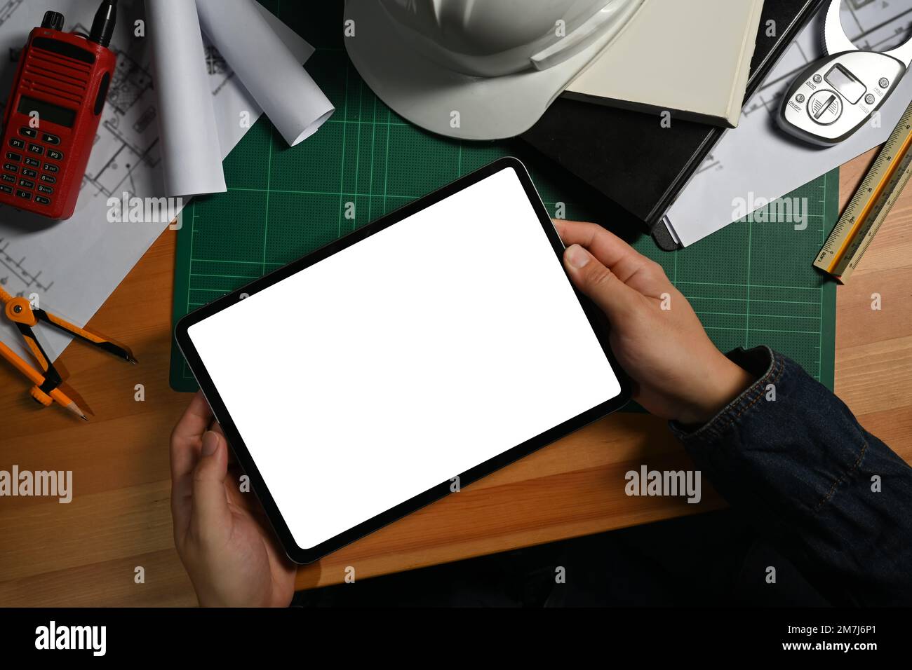 Engineer man using digital tablet and working with blueprints at ...