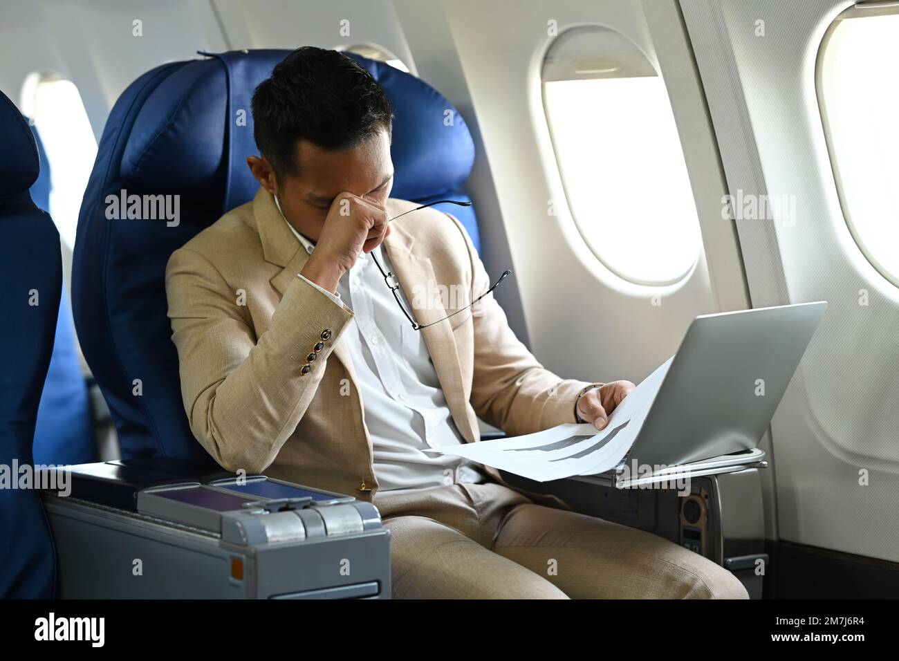 Stressed businessman working with financial document while sitting on ...