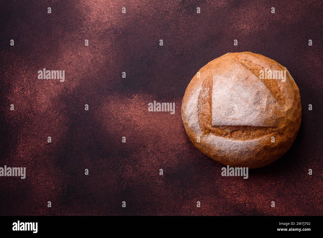 Beautiful delicious freshly baked round shaped white bread on a dark ...
