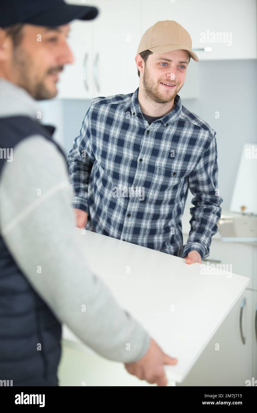 two men fitting new kitchen Stock Photo - Alamy